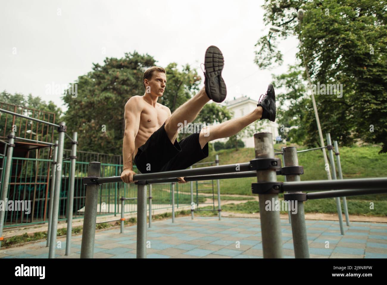 Well built muscular man doing a physical exercise outdoors. A muscular ...