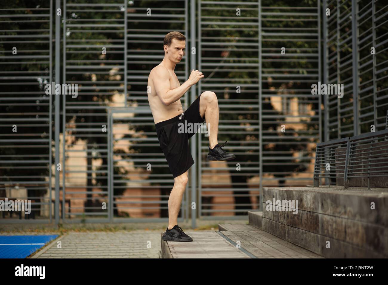 Attractive sporty muscular athlete stretches before a sports training ...