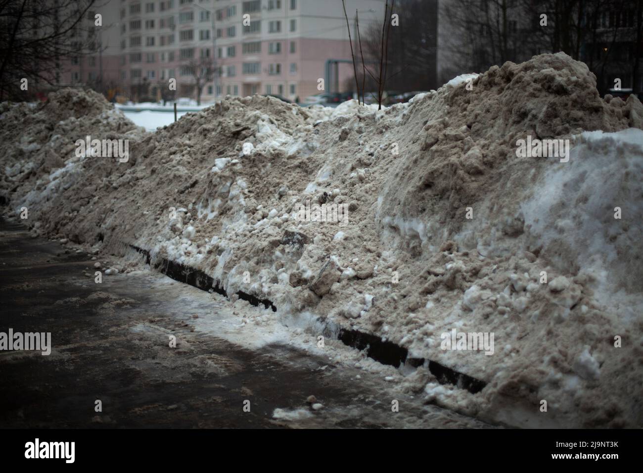 Snow in parking lot. Large snowdrift outside. Mountain of snow in yard ...