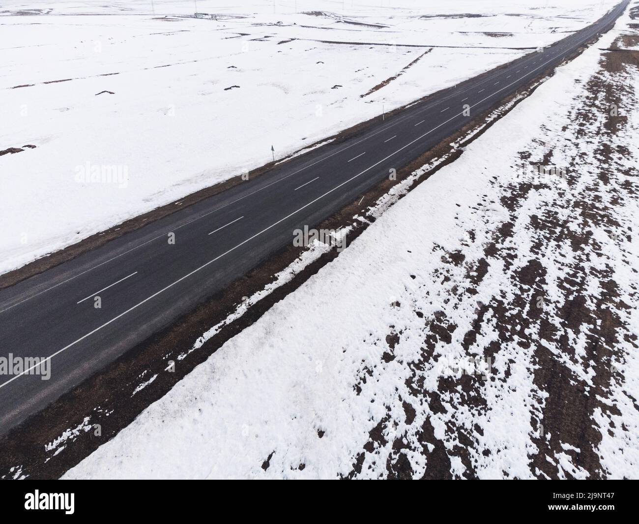 Aerial diagonal view of a road with one lane and snow in winter Stock ...