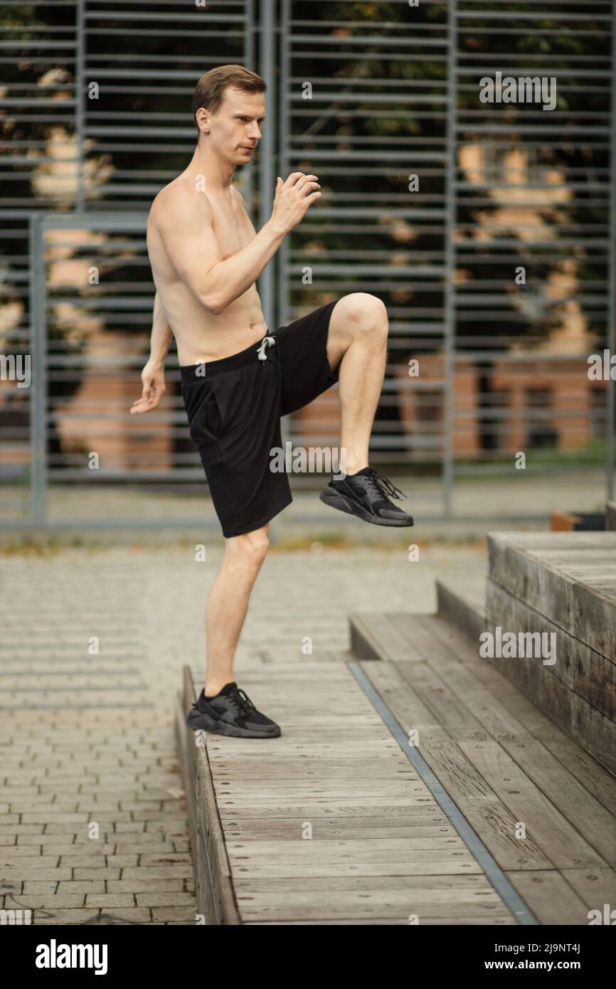 Attractive sporty muscular athlete stretches before a sports training ...
