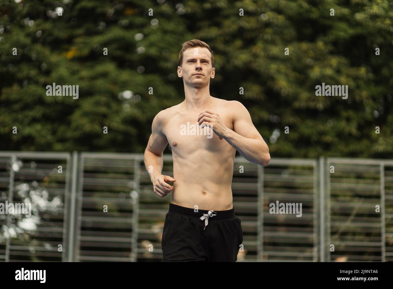 Positive sporty caucasian man in active outfit jogging at outdoor ...