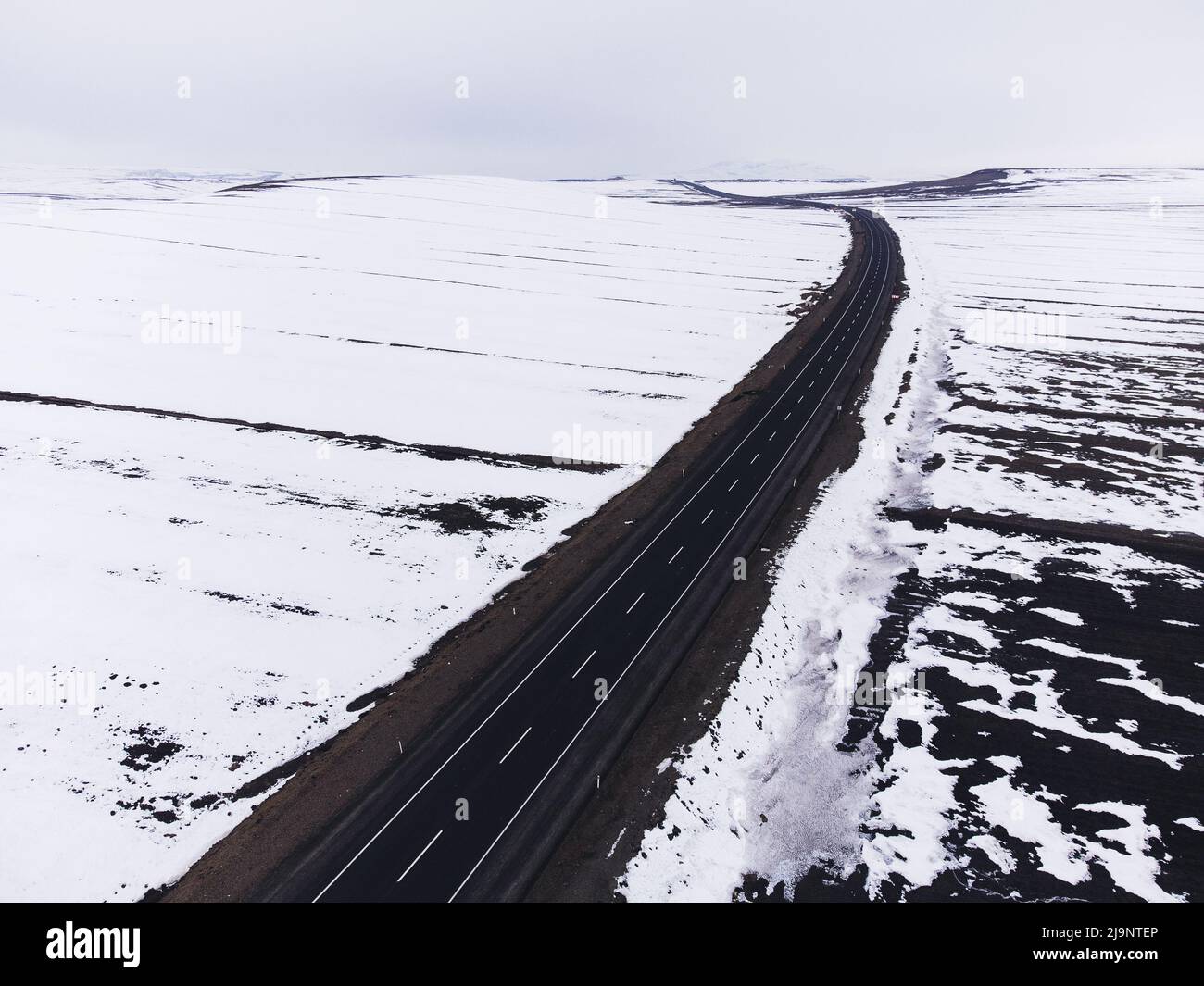 Aerial diagonal view of a road with one lane and snow in winter Stock ...