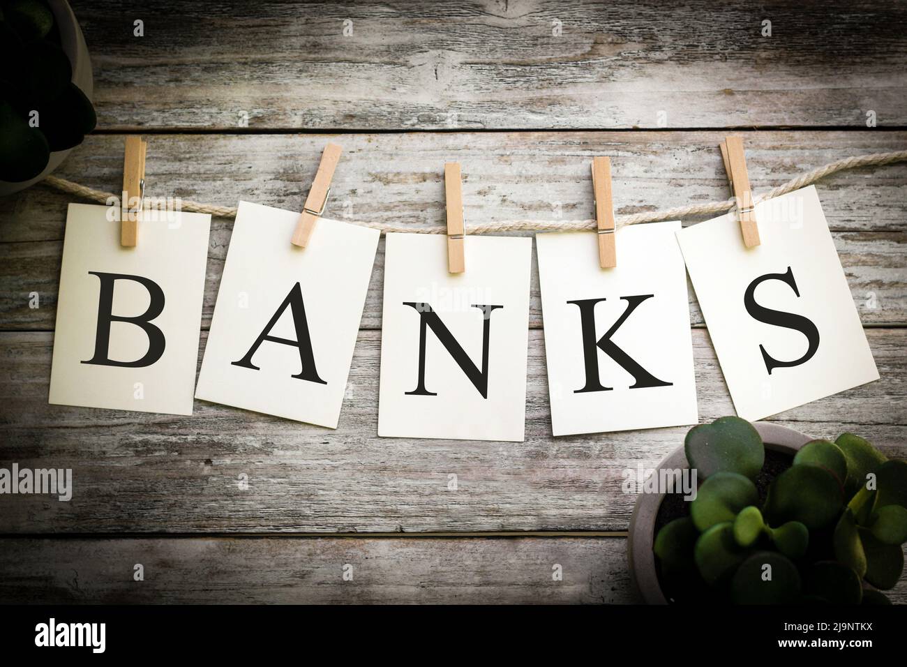 A set of printed cards spelling the word BANKS on an aged wooden ...