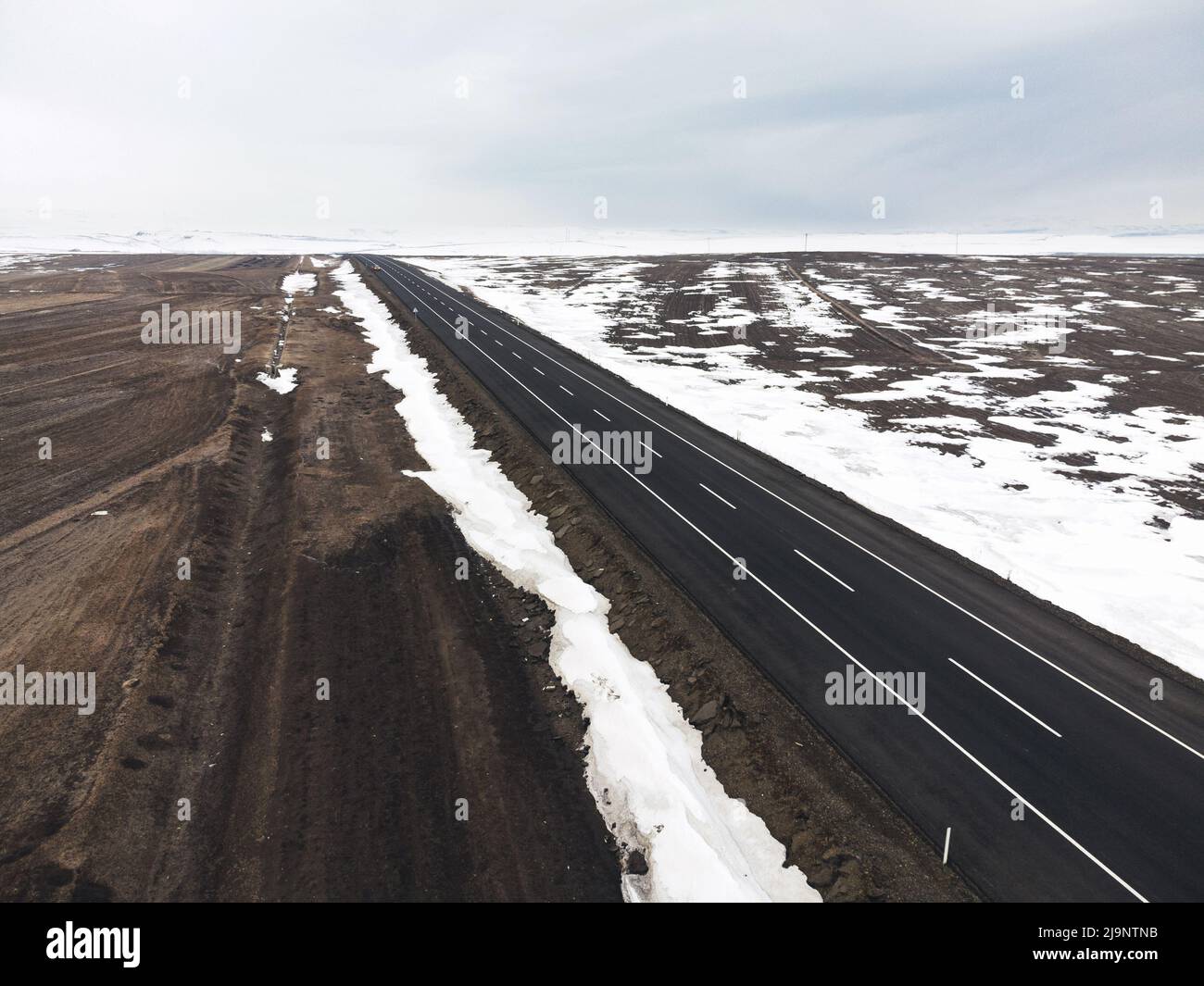 Aerial diagonal view of a road with one lane and snow in winter Stock ...