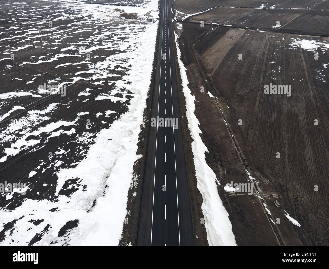 Aerial view of a road with one lane and snow in winter Stock Photo - Alamy