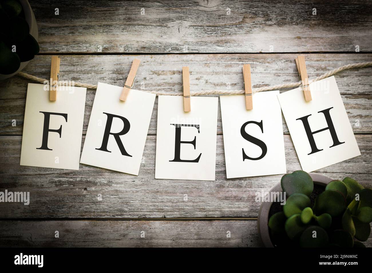 A set of printed cards spelling the word FRESH on an aged wooden ...