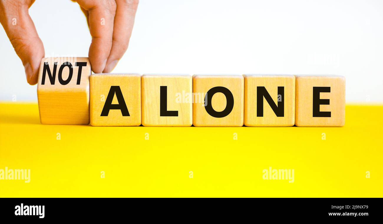 You are not alone symbol. Businessman turns wooden cubes and changes ...