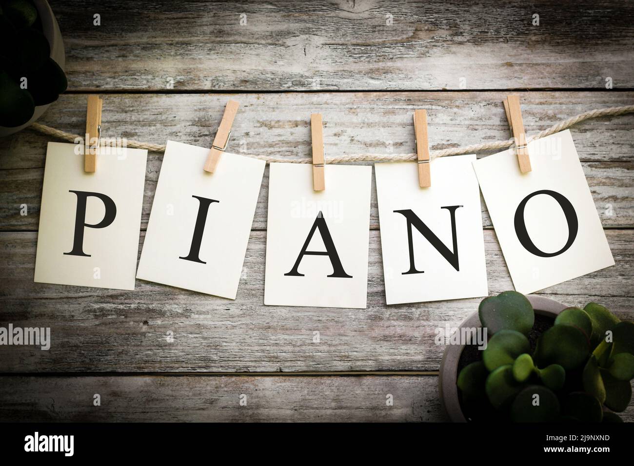 A set of printed cards spelling the word PIANO on an aged wooden ...