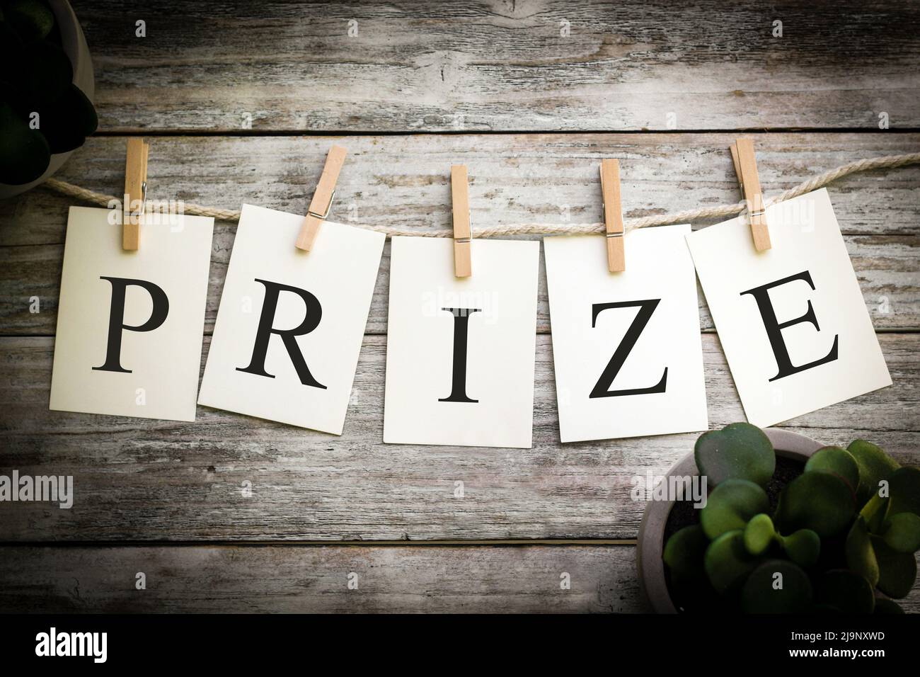 A set of printed cards spelling the word PRIZE on an aged wooden ...