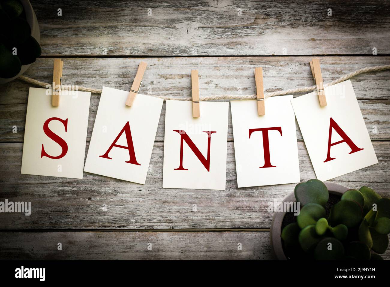 A set of printed cards spelling the word SANTA on an aged wooden ...