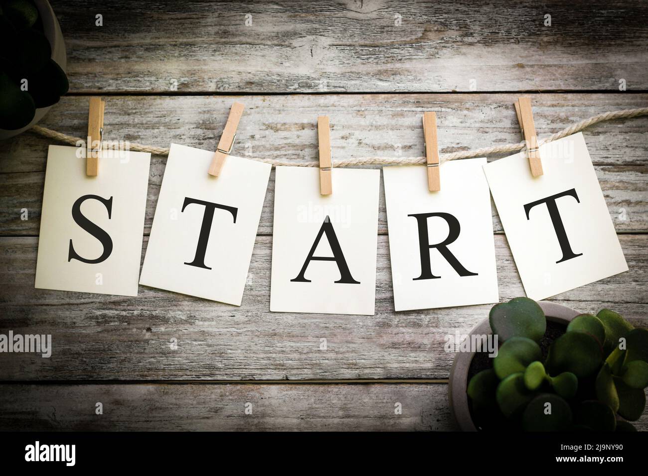 A set of printed cards spelling the word START on an aged wooden ...