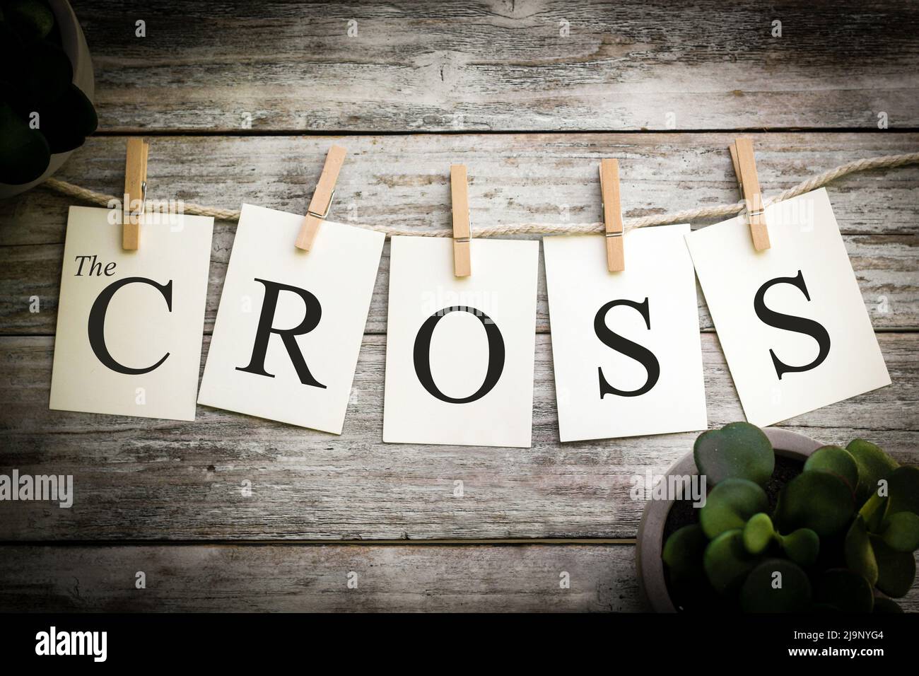 A set of printed cards spelling the words THE CROSS on an aged wooden ...