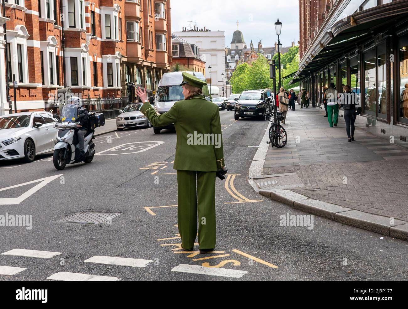 A Female Harrods doorman hails a cab outside the iconic department ...