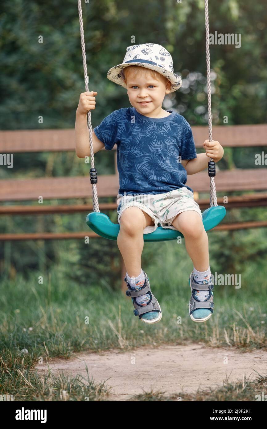 Little boy playing on swing in backyard at countryside Stock Photo - Alamy