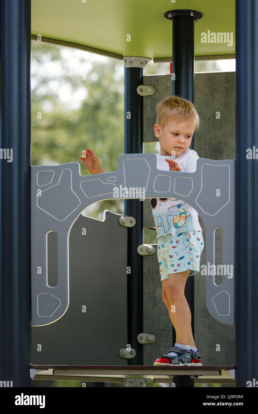 The little boy climbs high up to the playground observation tower Stock ...