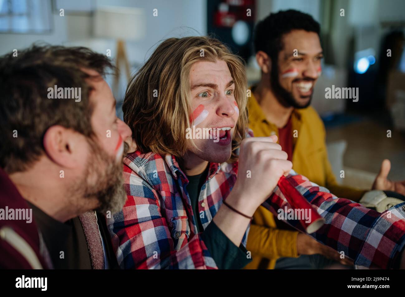 Happy Austrian football fans friends watching football at home and ...