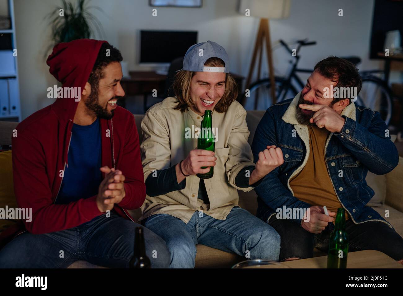 Happy football fans friends watching football at home and talking Stock ...