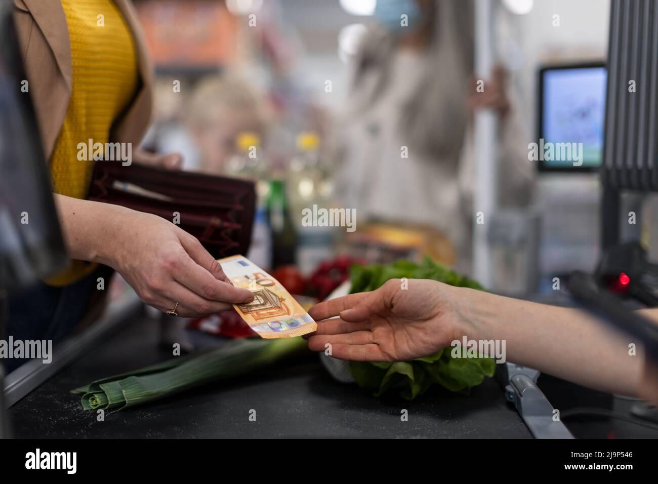 Close-up of woman giving money at the cash desk in supermarket Stock ...