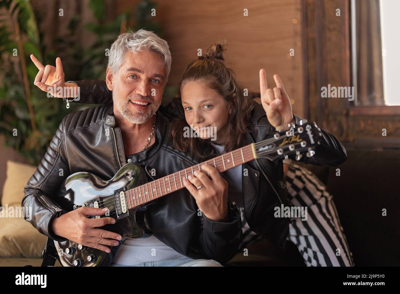 Father rock guitarist having fun and and dancing with his teenage ...