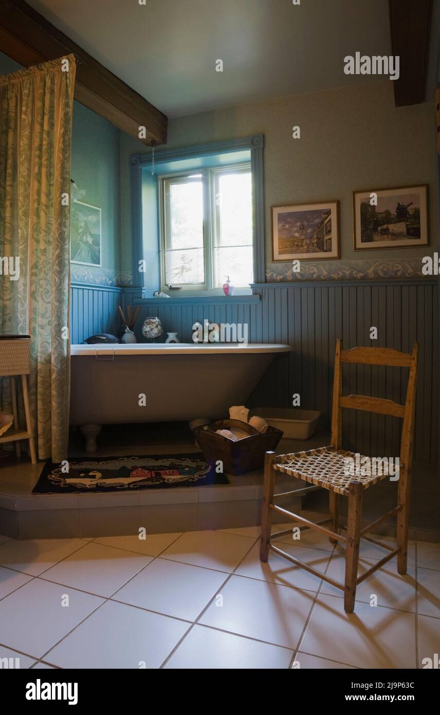 Antique chair and roll top bathtub on elevated platform in main ...