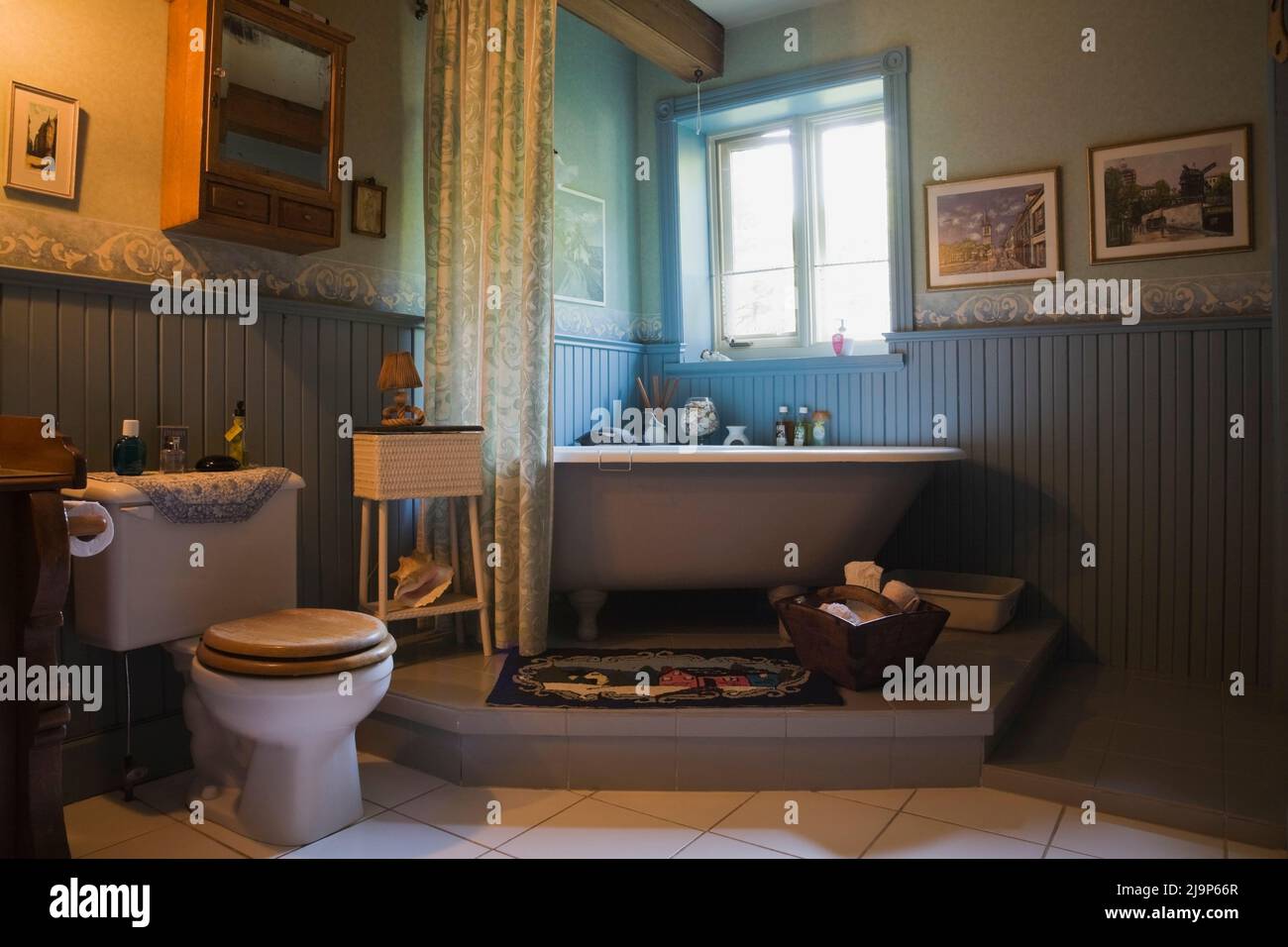 Roll top bathtub on elevated platform and toilet in main bathroom ...