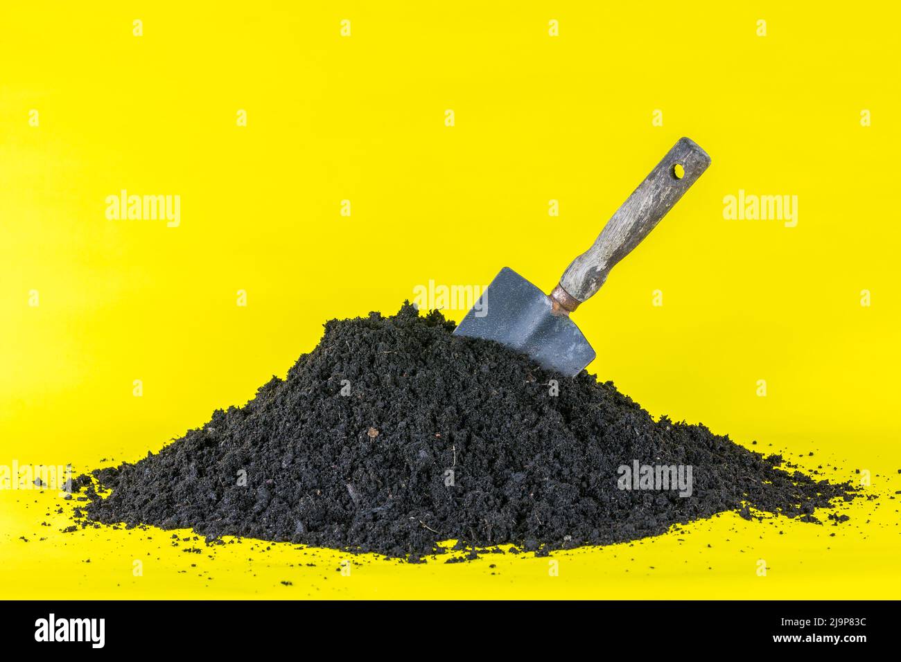 Pile of soil isolated on a bright yellow background, with a garden ...