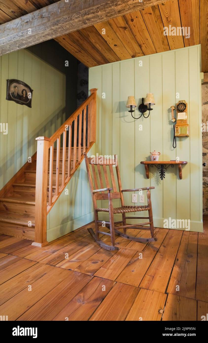 Antique rocking chair next to staircase leading to upstairs floor ...