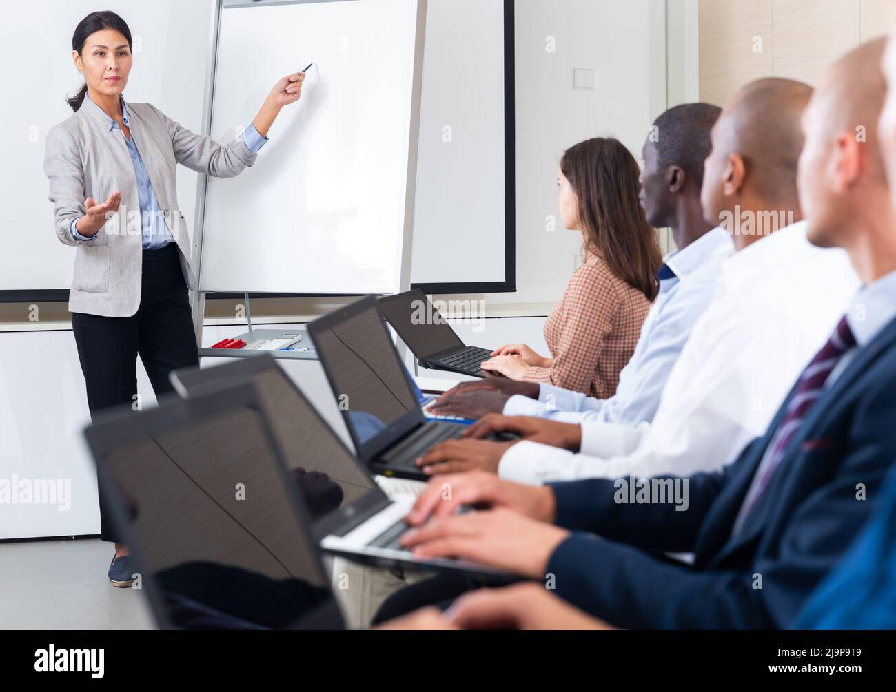 Female speaker giving talk on corporate business meeting in room Stock ...