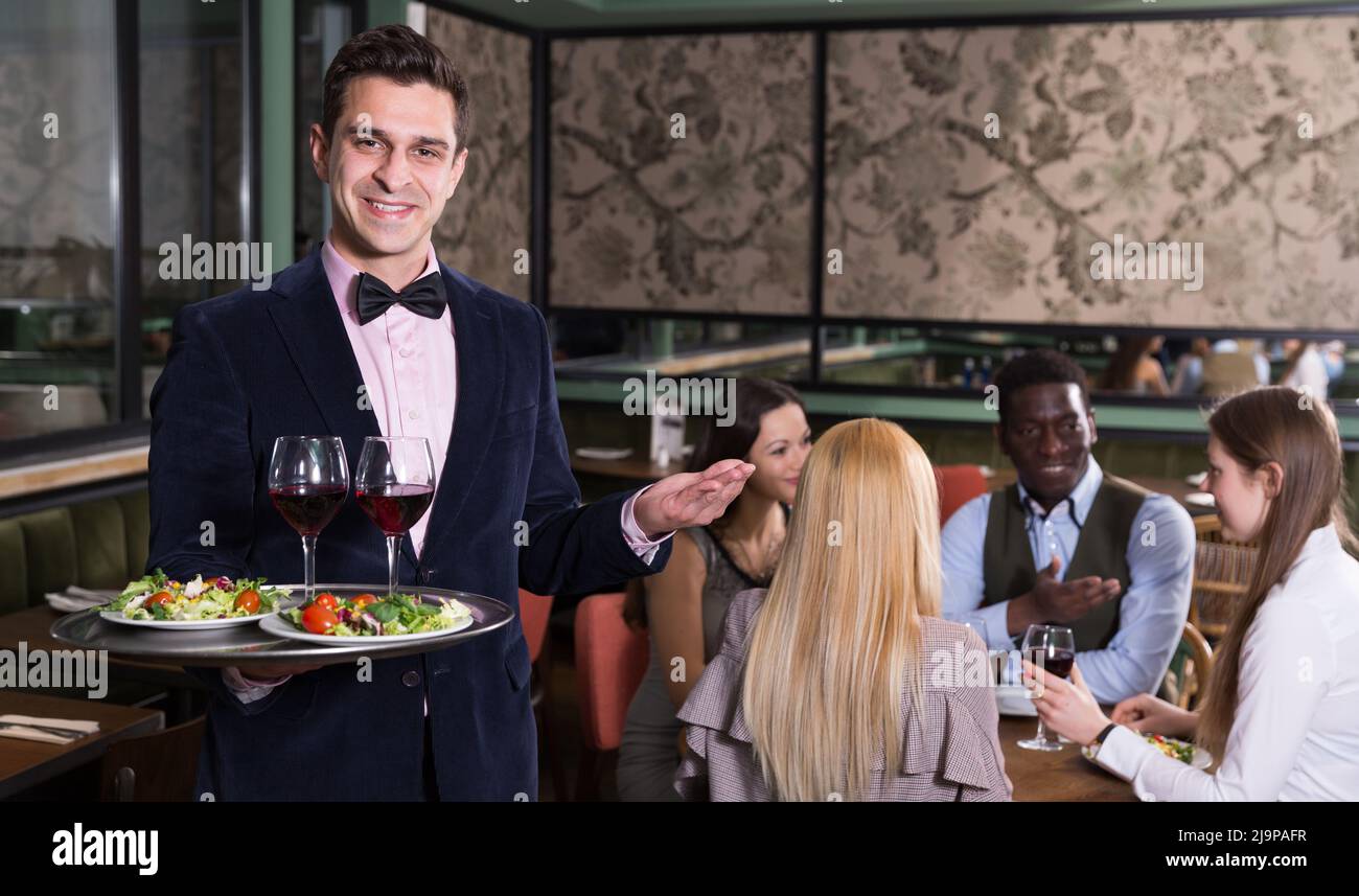 Smiling waiter with serving tray Stock Photo - Alamy