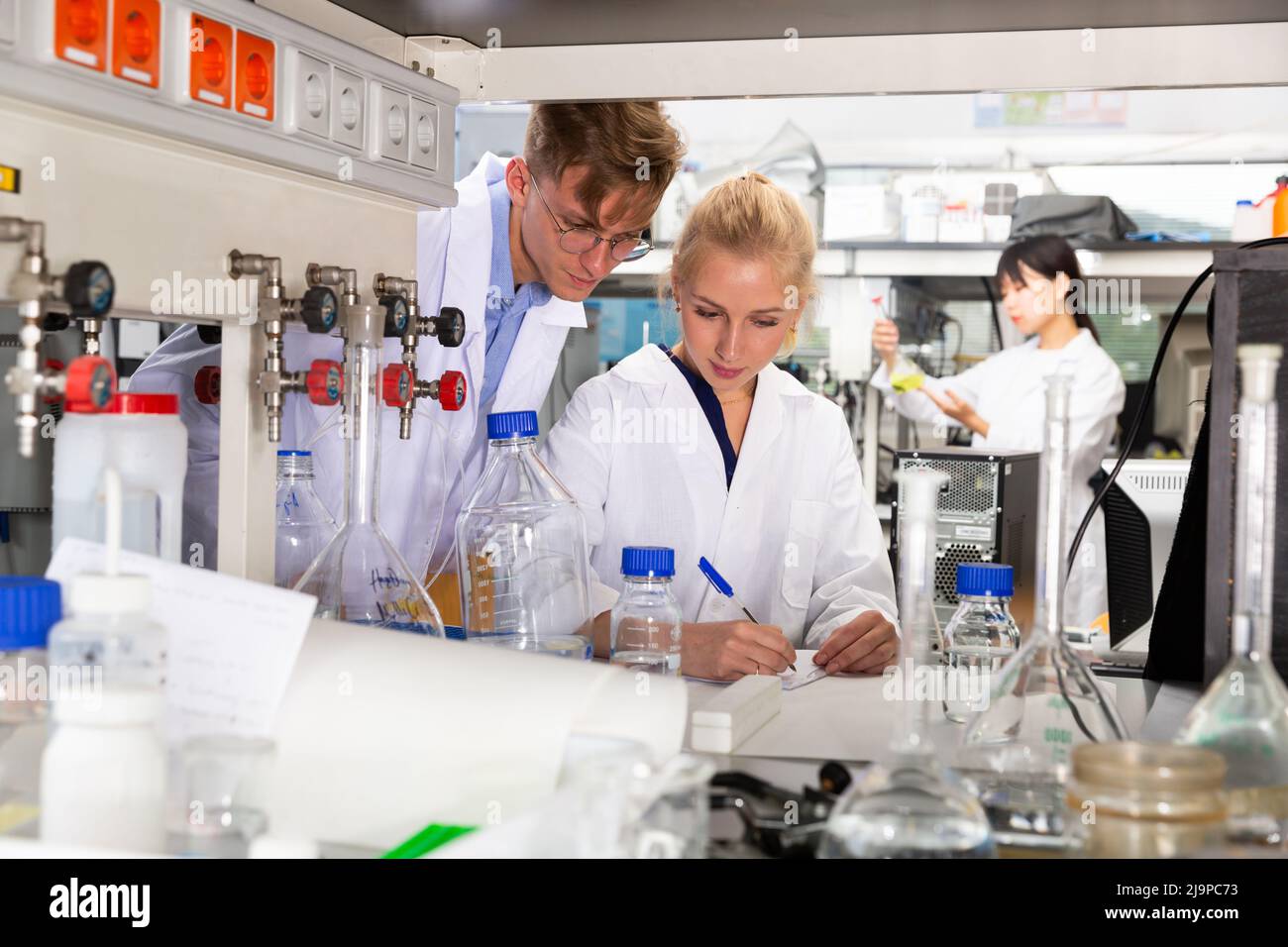 Two students recording results of experiments Stock Photo - Alamy