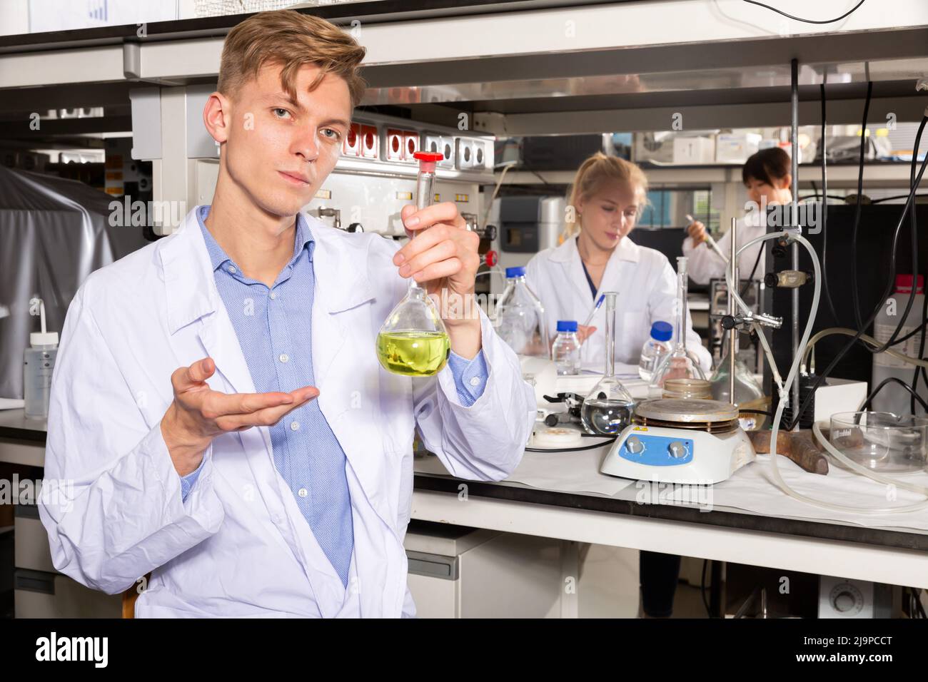 Male scientist holding flask of reagent Stock Photo - Alamy