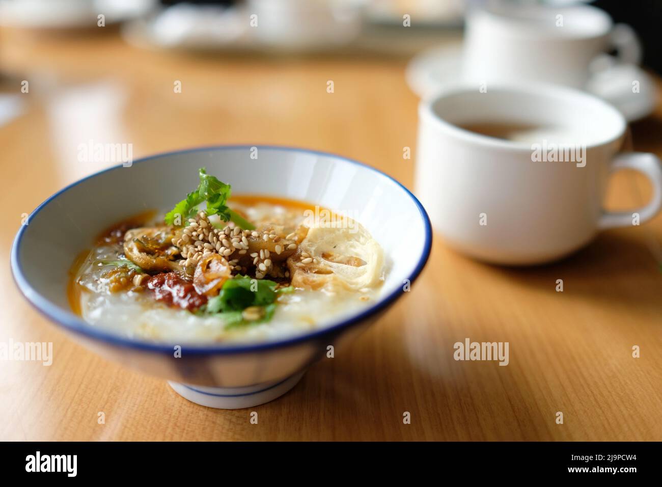 A bowl of Japanese rice porridge with traditional condiments at hotel ...