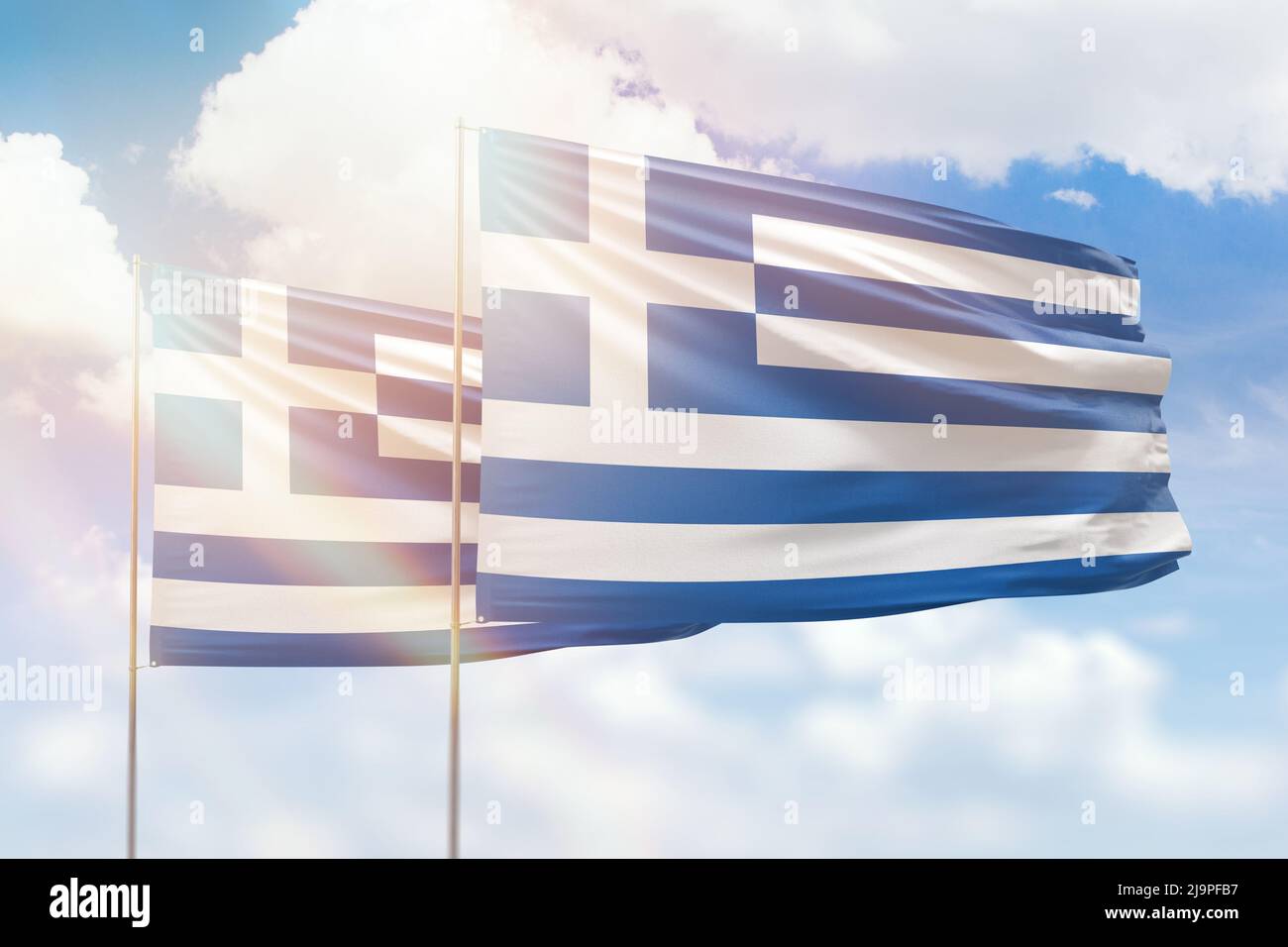 Sunny blue sky and flags of greece and greece Stock Photo - Alamy