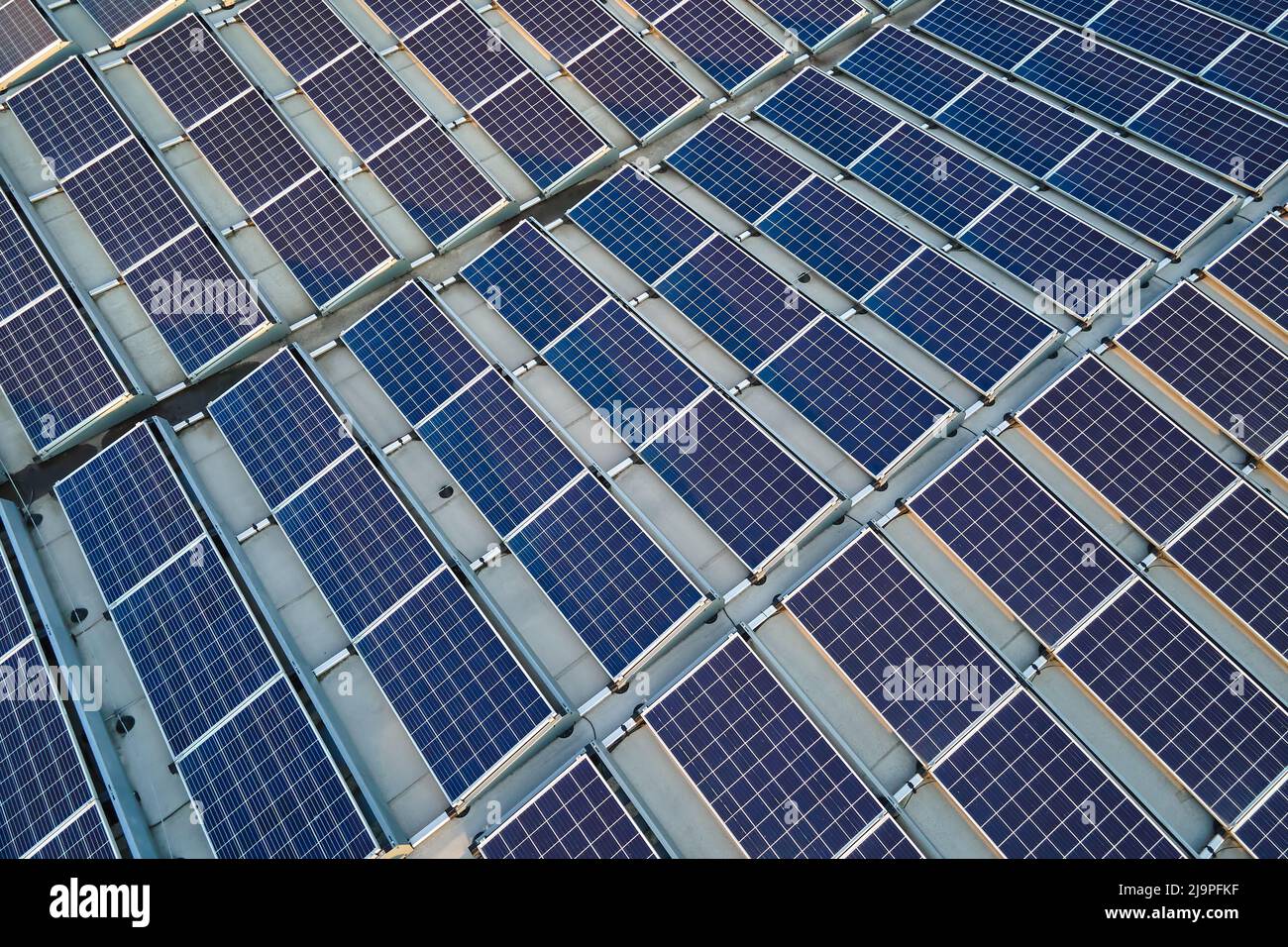 Aerial view of blue photovoltaic solar panels mounted on industrial ...