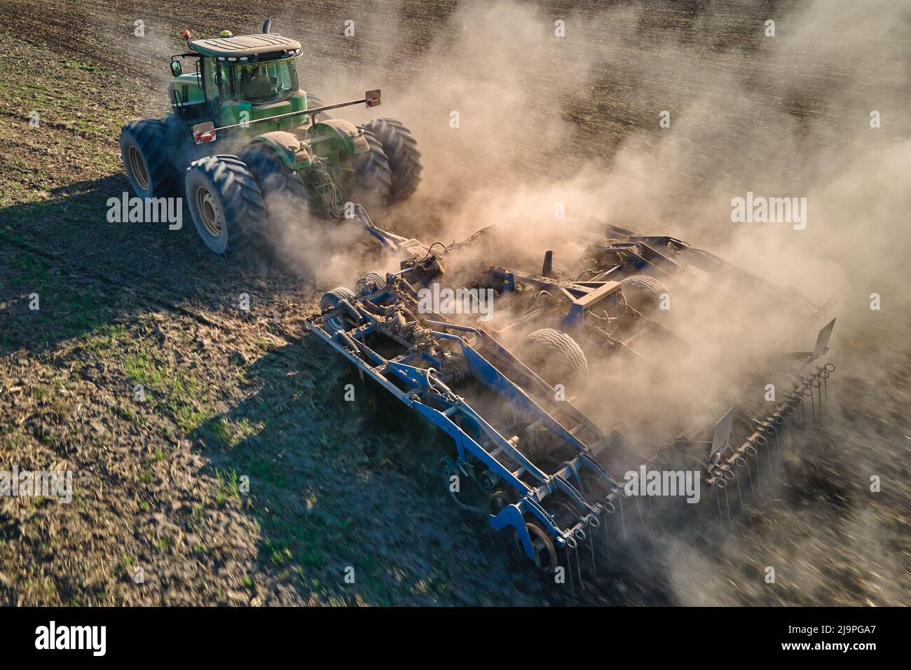 Aerial view of tractor plowing agriculural farm field preparing soil ...