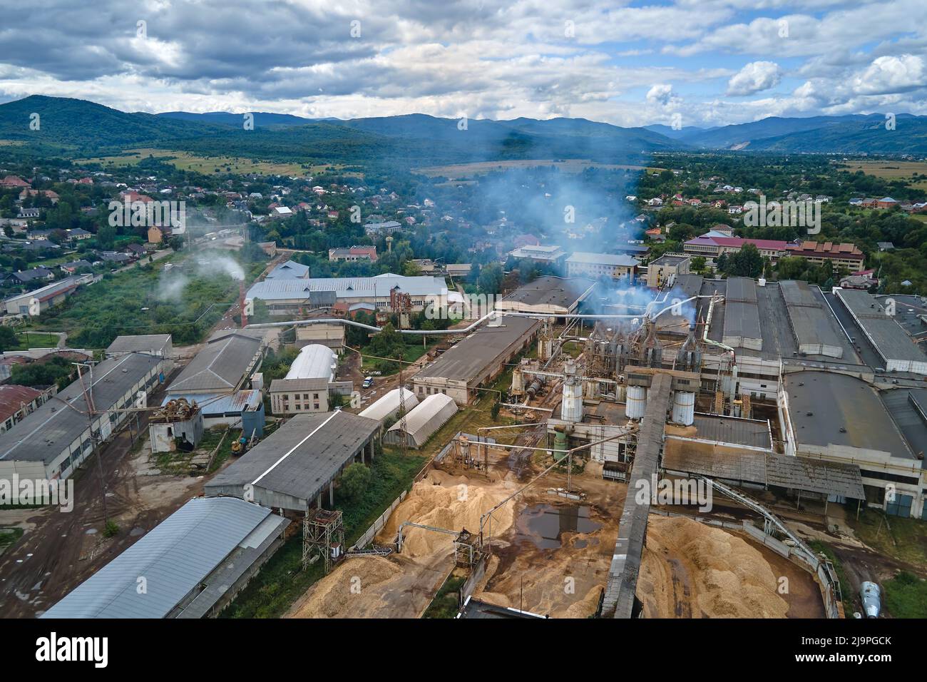 Aerial view of wood processing factory with smoke from production ...