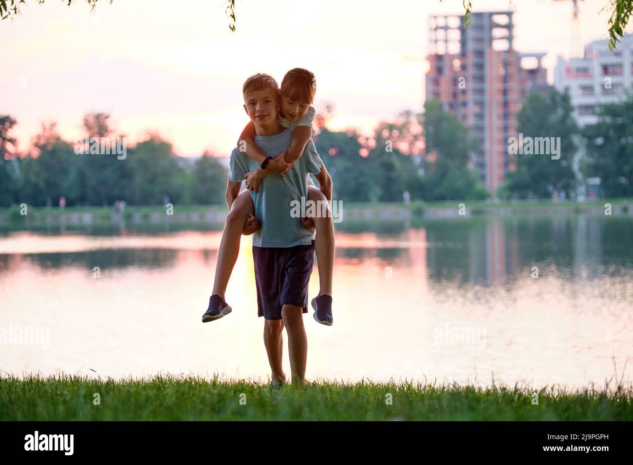Happy siblings hugging lovingly in summer park. Young children brother ...