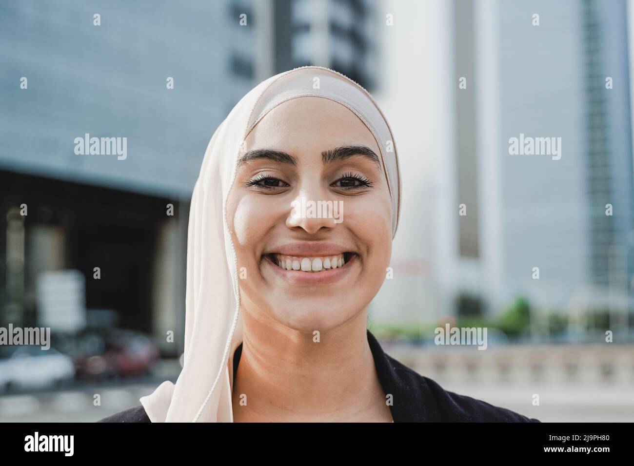 Muslim business woman working outside with office buildings on ...