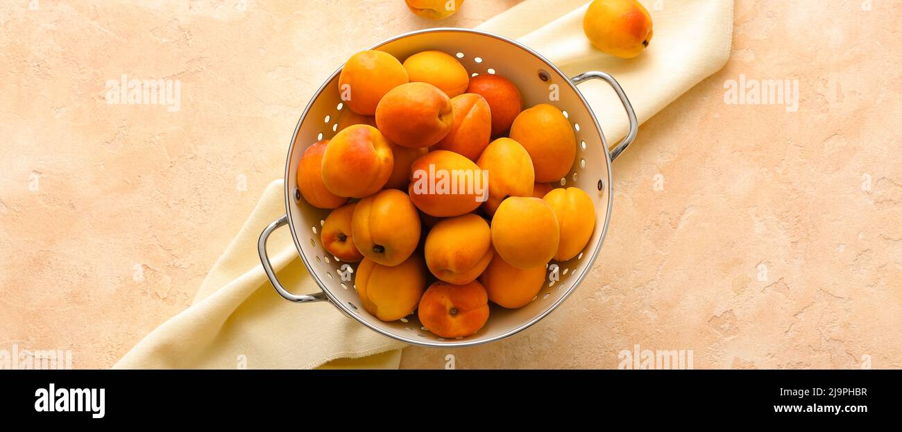 Colander with tasty ripe apricots on color background, top view Stock ...