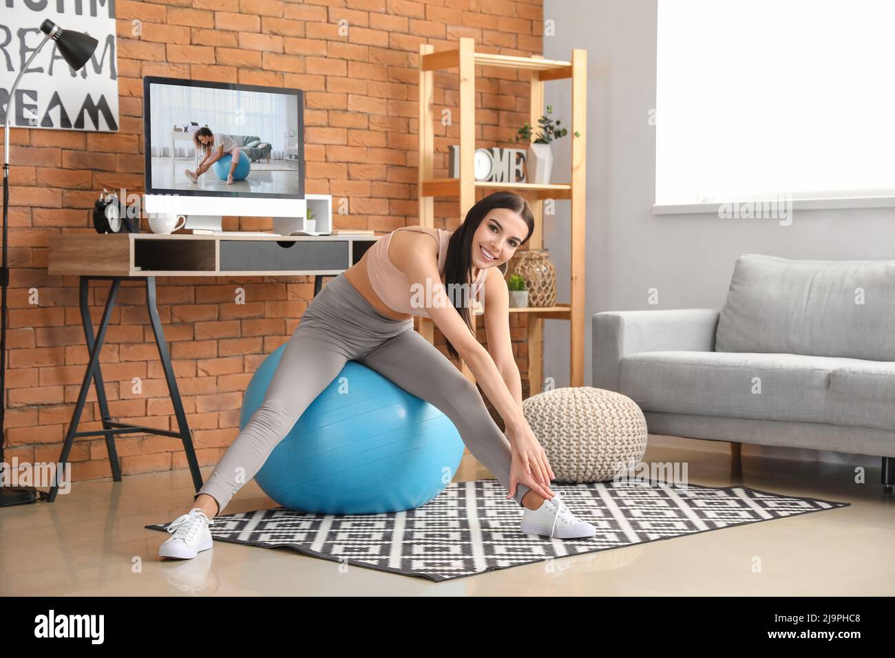 Woman doing exercises with fitball at home. Concept of online training ...