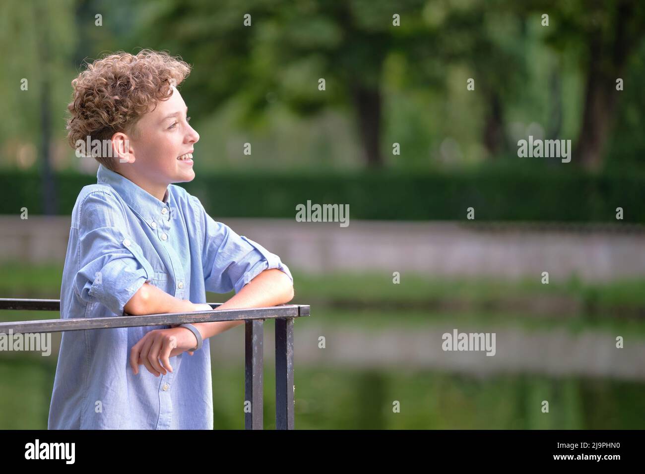 Young happy child boy relaxing in summer park. Positive kid enjoying ...