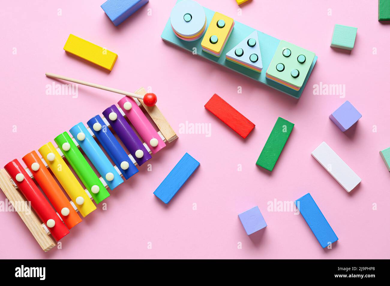 Children building blocks with xylophone on pink background Stock Photo ...