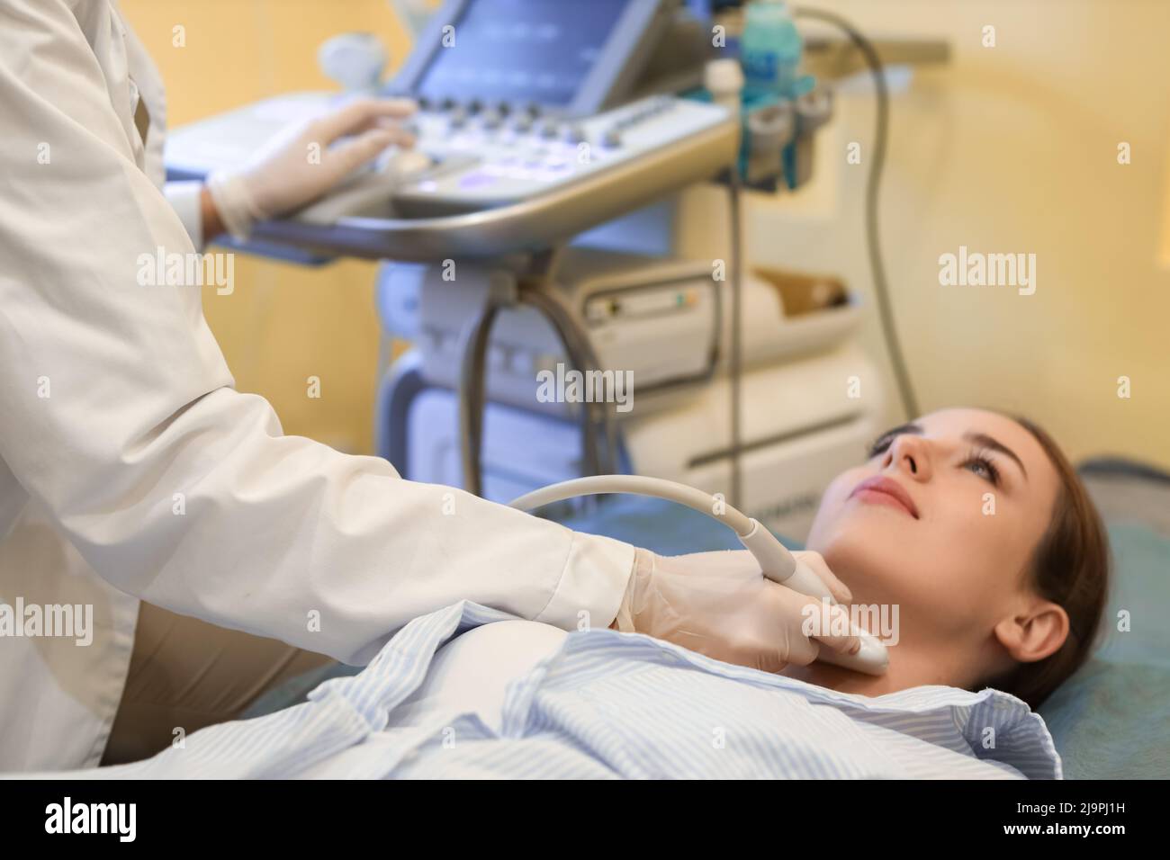 Young woman getting thyroid ultrasound examination in modern clinic ...