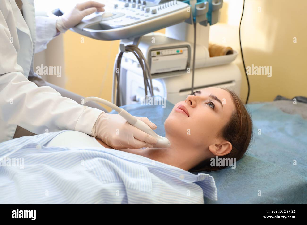 Young woman getting thyroid ultrasound examination in modern clinic ...