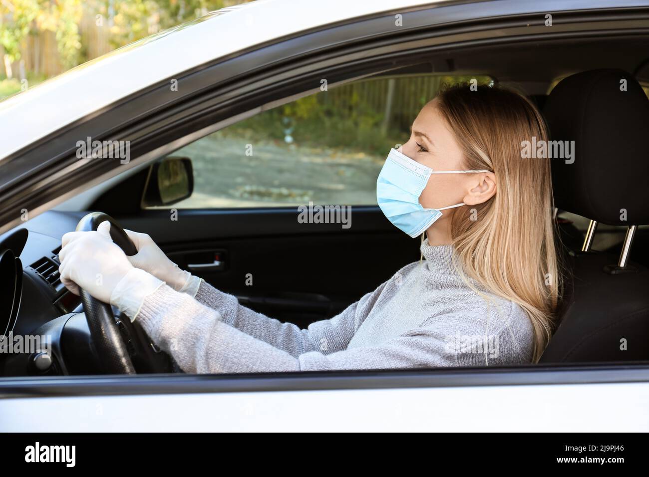Female driver wearing medical mask in car Stock Photo - Alamy