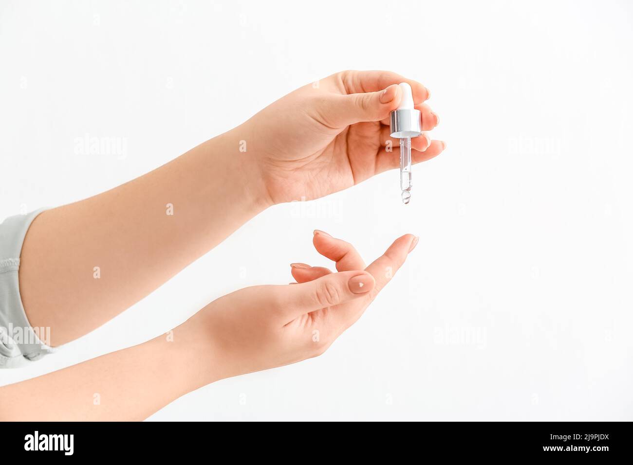 Woman applying serum onto hand on white background, closeup Stock Photo ...