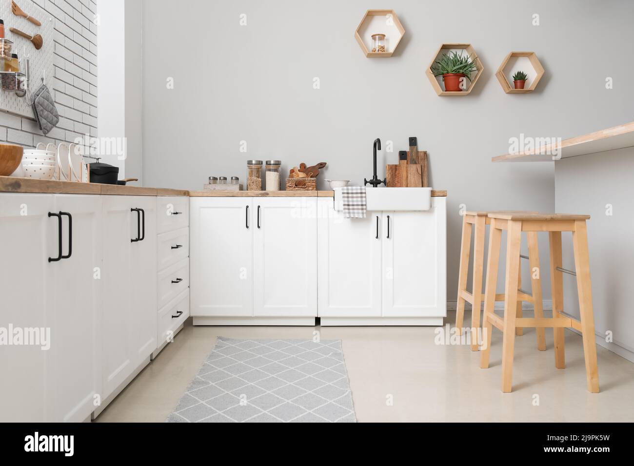Interior of light kitchen with counters, utensils and stools Stock ...