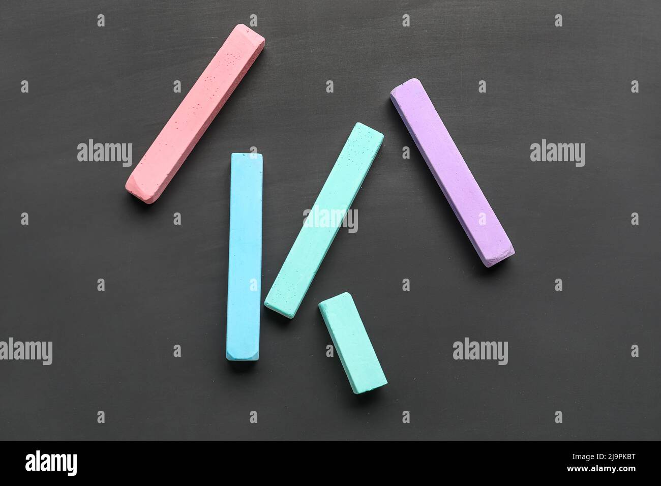 Colorful chalks on blackboard, top view Stock Photo - Alamy