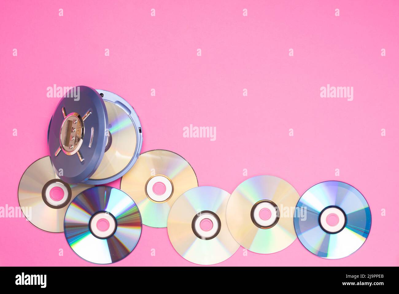 Personal compact portable CD player discs bright pink background. Top ...